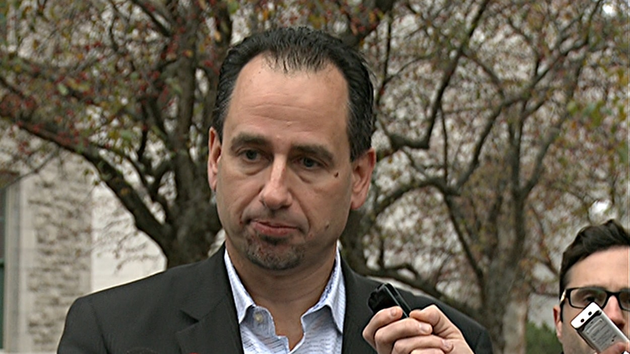 Un autobus d'OC Transpo s'arrête à quelques mètres de la voie ferrée ...